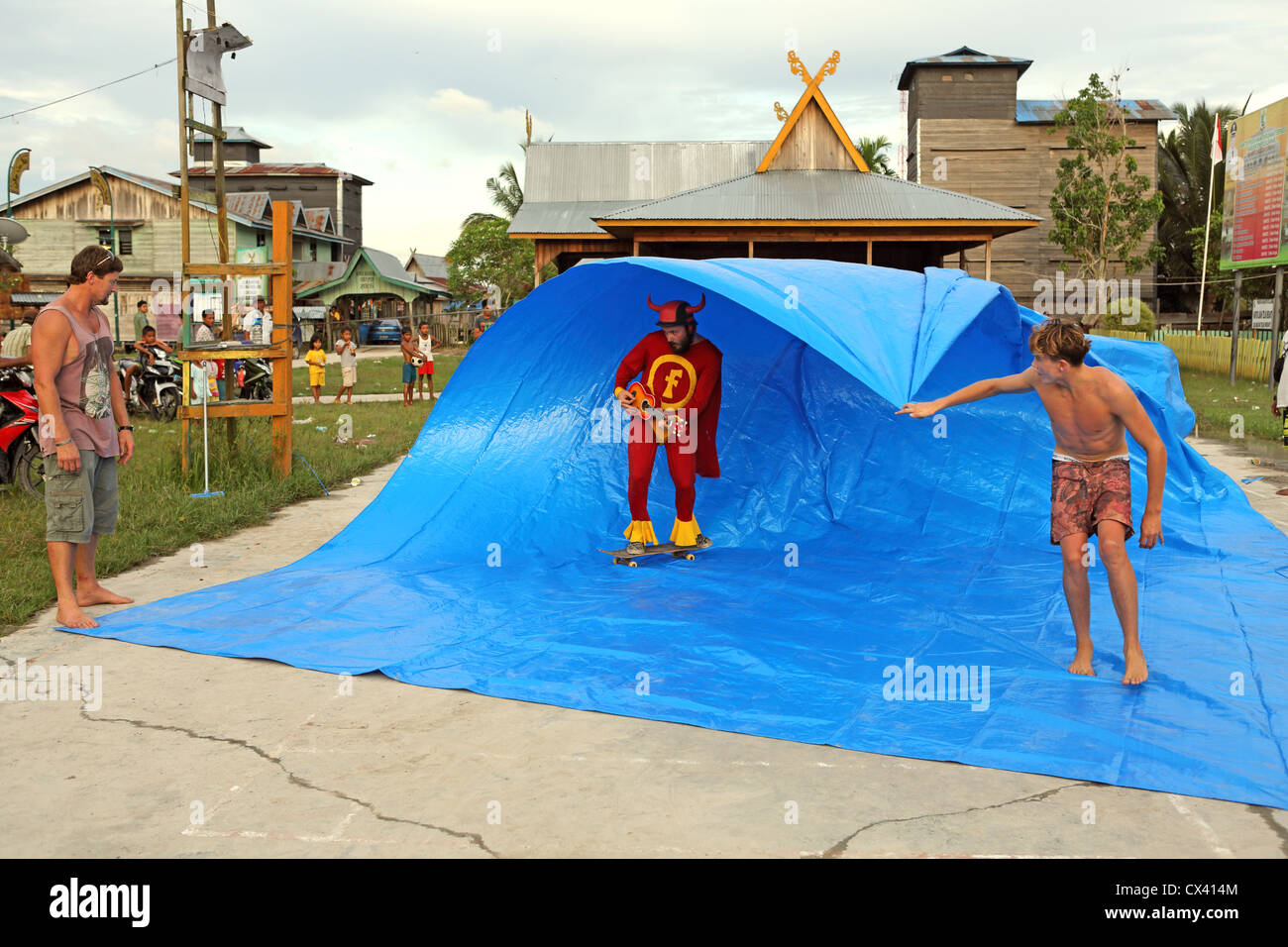 Crazy bearded man in red superhero costume performing a tarp surfing ...