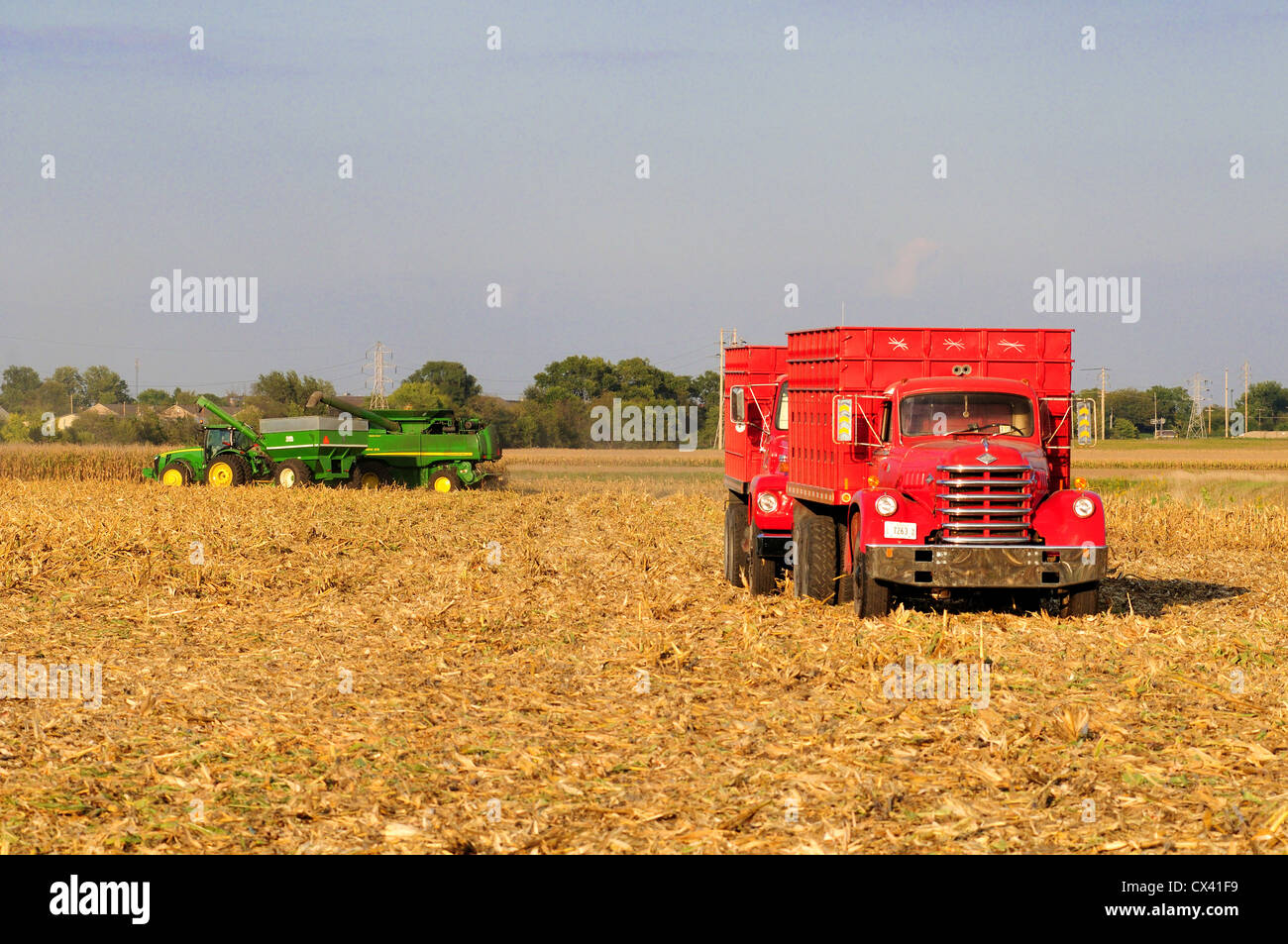 Harvesting corn with a John Deere combine and tractor hauling grain ...