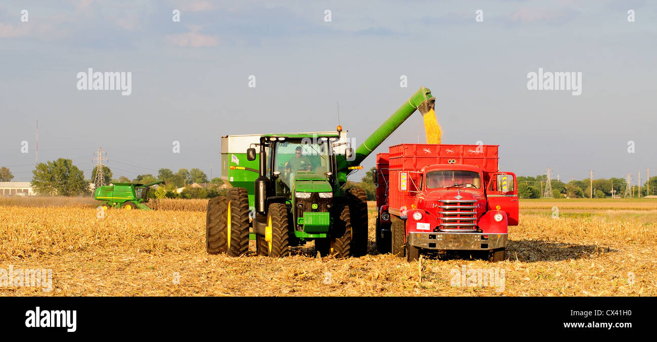 Harvesting corn with a John Deere combine and tractor hauling grain ...