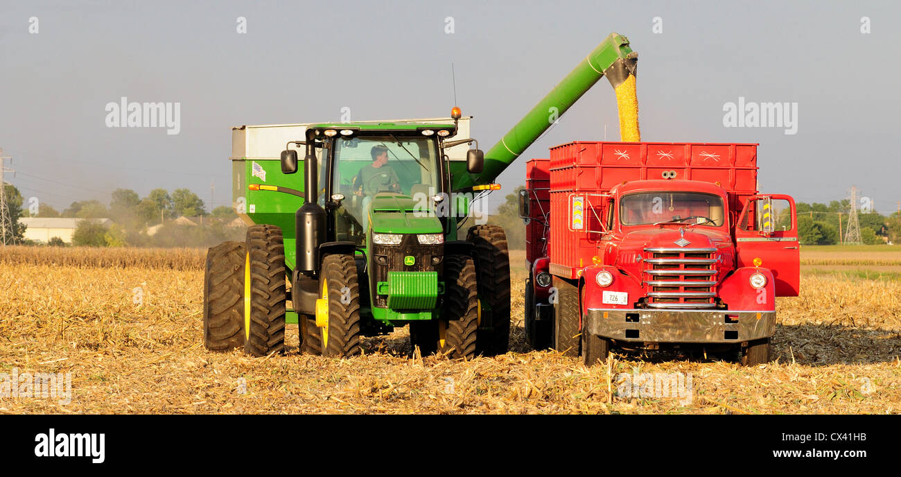 Harvesting corn with a John Deere combine and tractor hauling grain ...