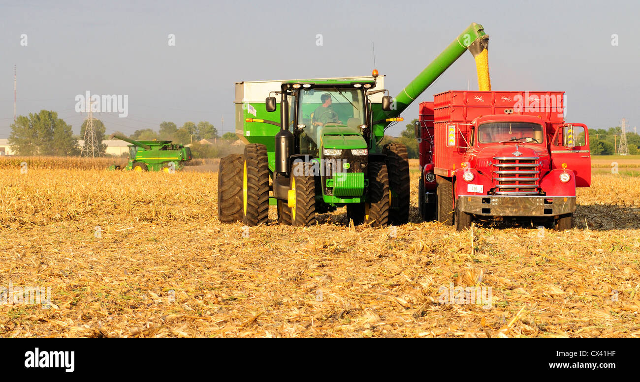 Harvesting corn with a John Deere combine and tractor hauling grain ...