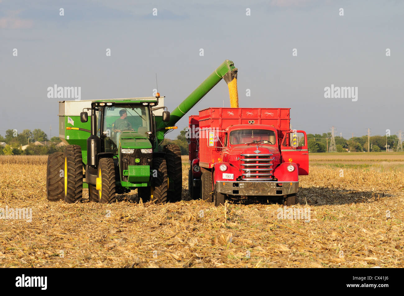 Harvesting corn with a John Deere combine and tractor hauling grain ...