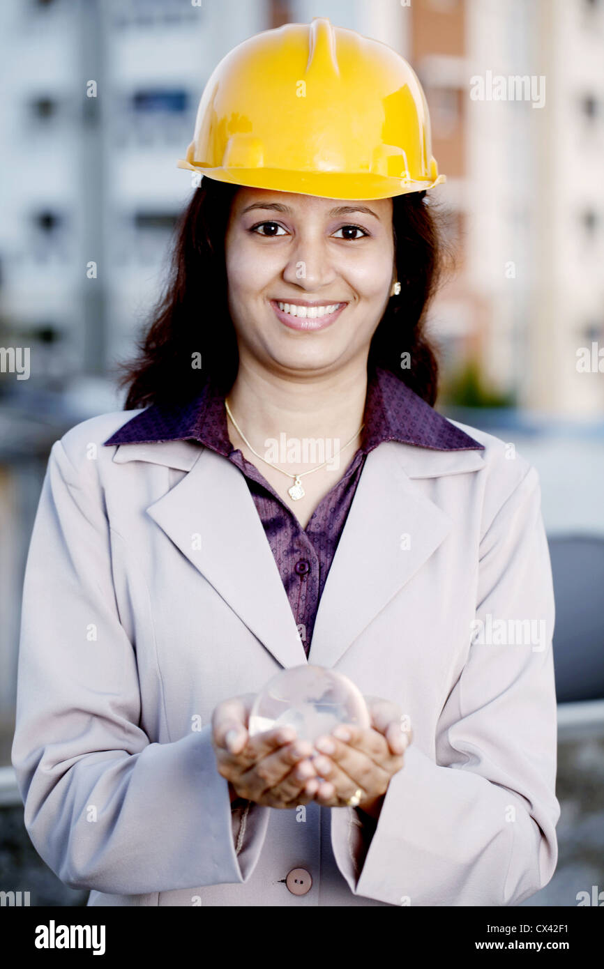 Young female Industrial engineer holding a globe Stock Photo - Alamy