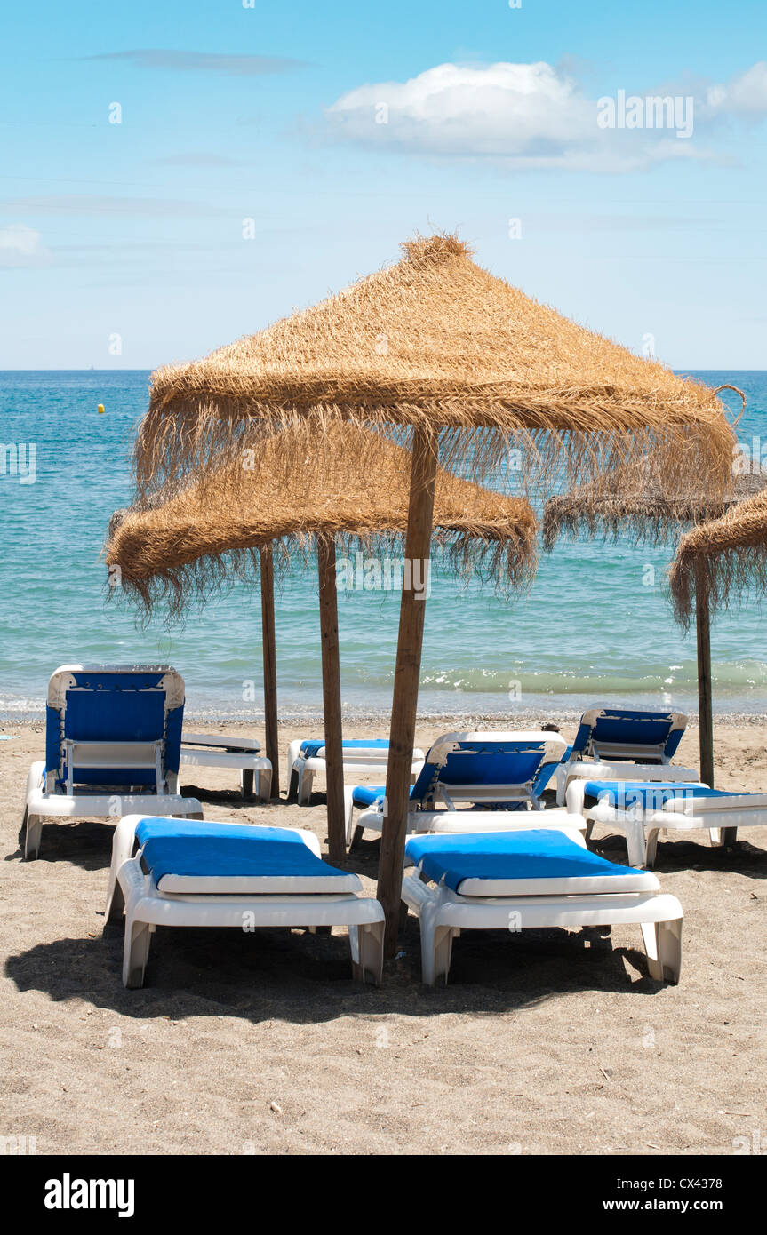 Straw beach umbrellas and sunbeds on the beach Stock Photo - Alamy