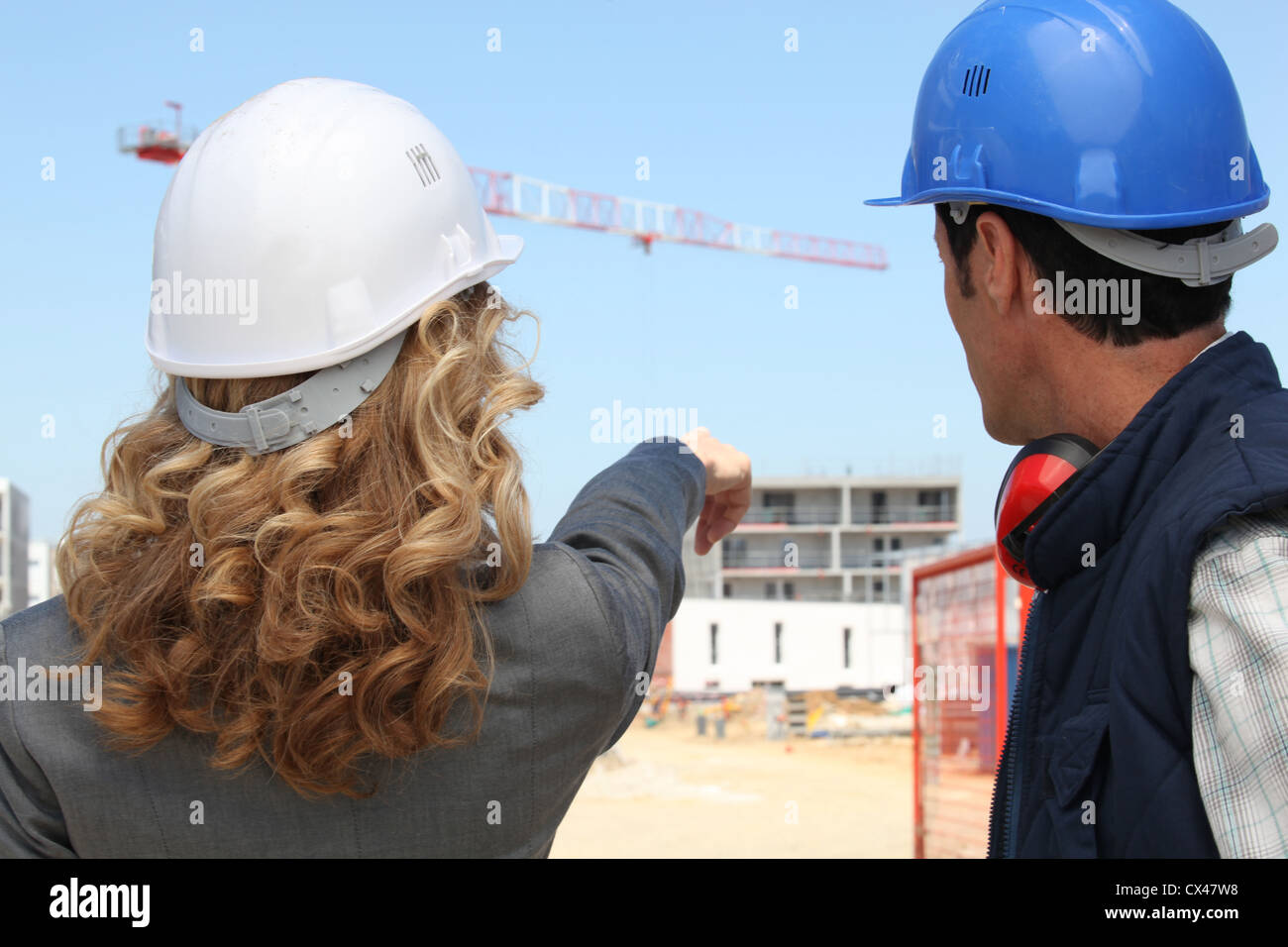 Tradesman and an engineer working together on a construction site Stock ...