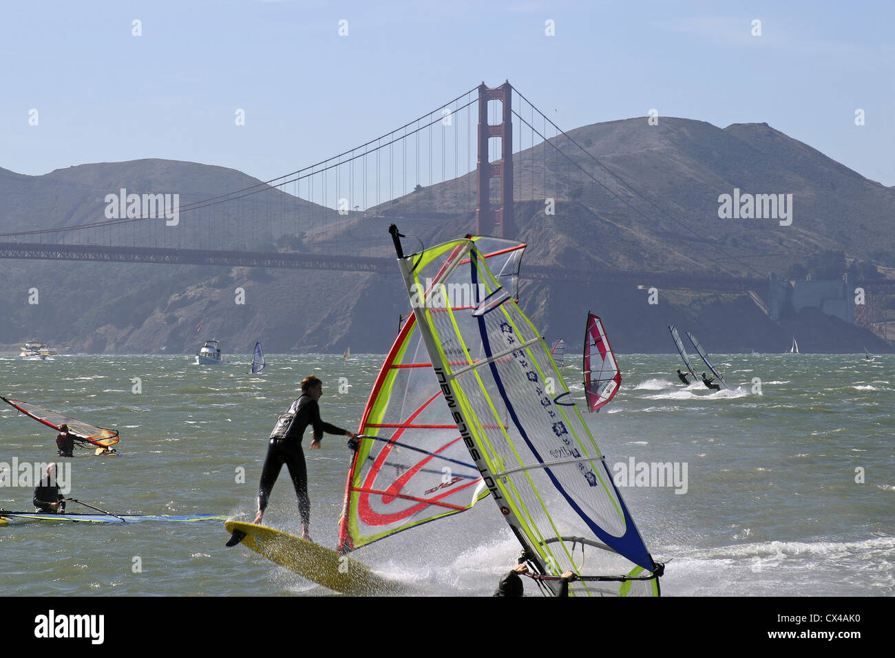 Windsurfers enjoy the strong winds blowing under the Golden Gate Bridge ...