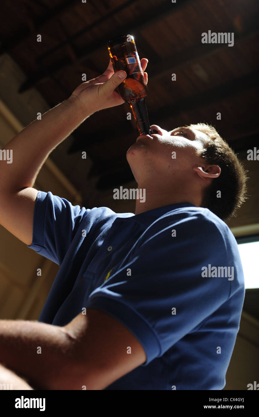 Teenage boy drinking beer in a basement of a house - underage under age ...