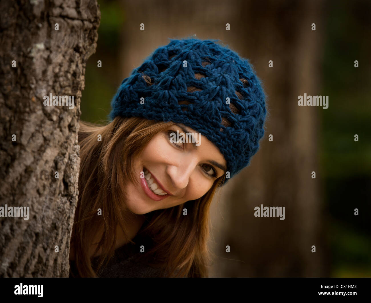 Pretty woman peeking behind tree hi-res stock photography and images ...