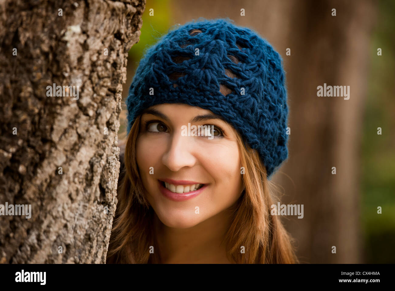 Pretty woman peeking behind tree hi-res stock photography and images ...