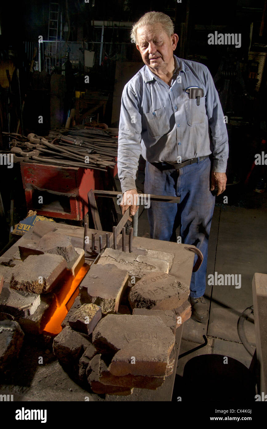 An elderly blacksmith in a Tustin, CA, barn built in 1912 heats a hot ...