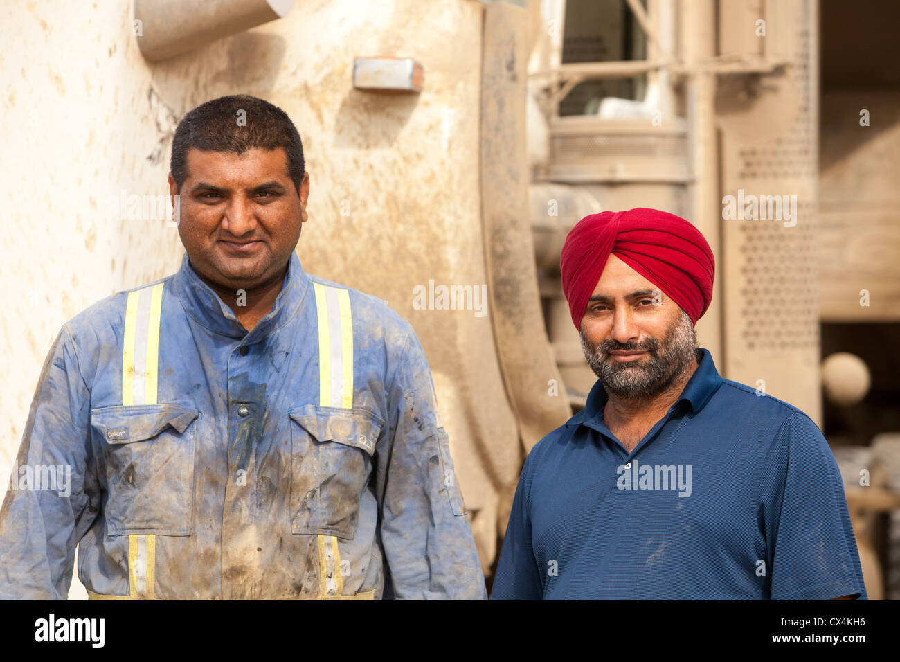 Tar sands workers working on trucks at a mine north of Fort McMurray ...