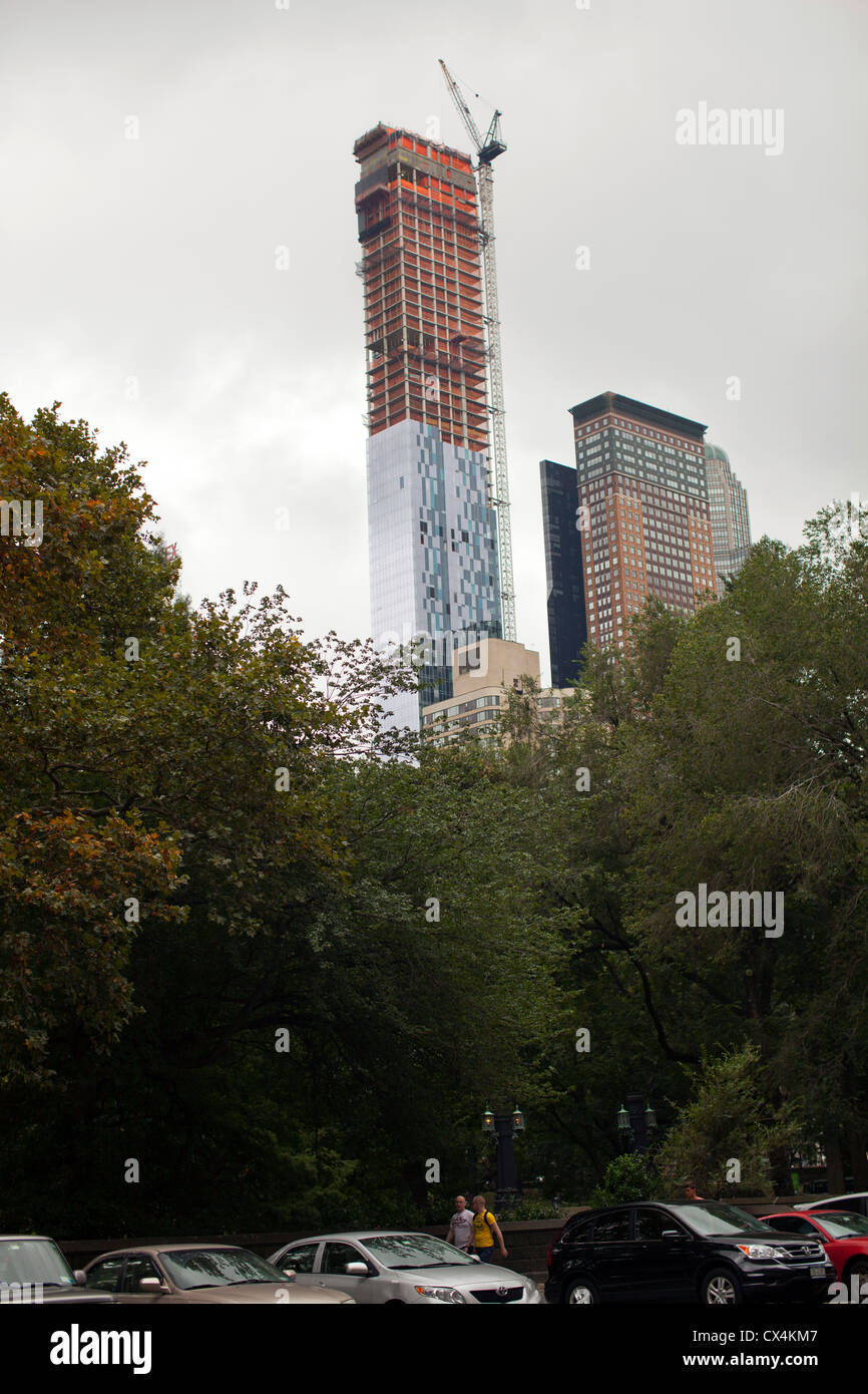 A tall, narrow residential apartment building is under construction ...