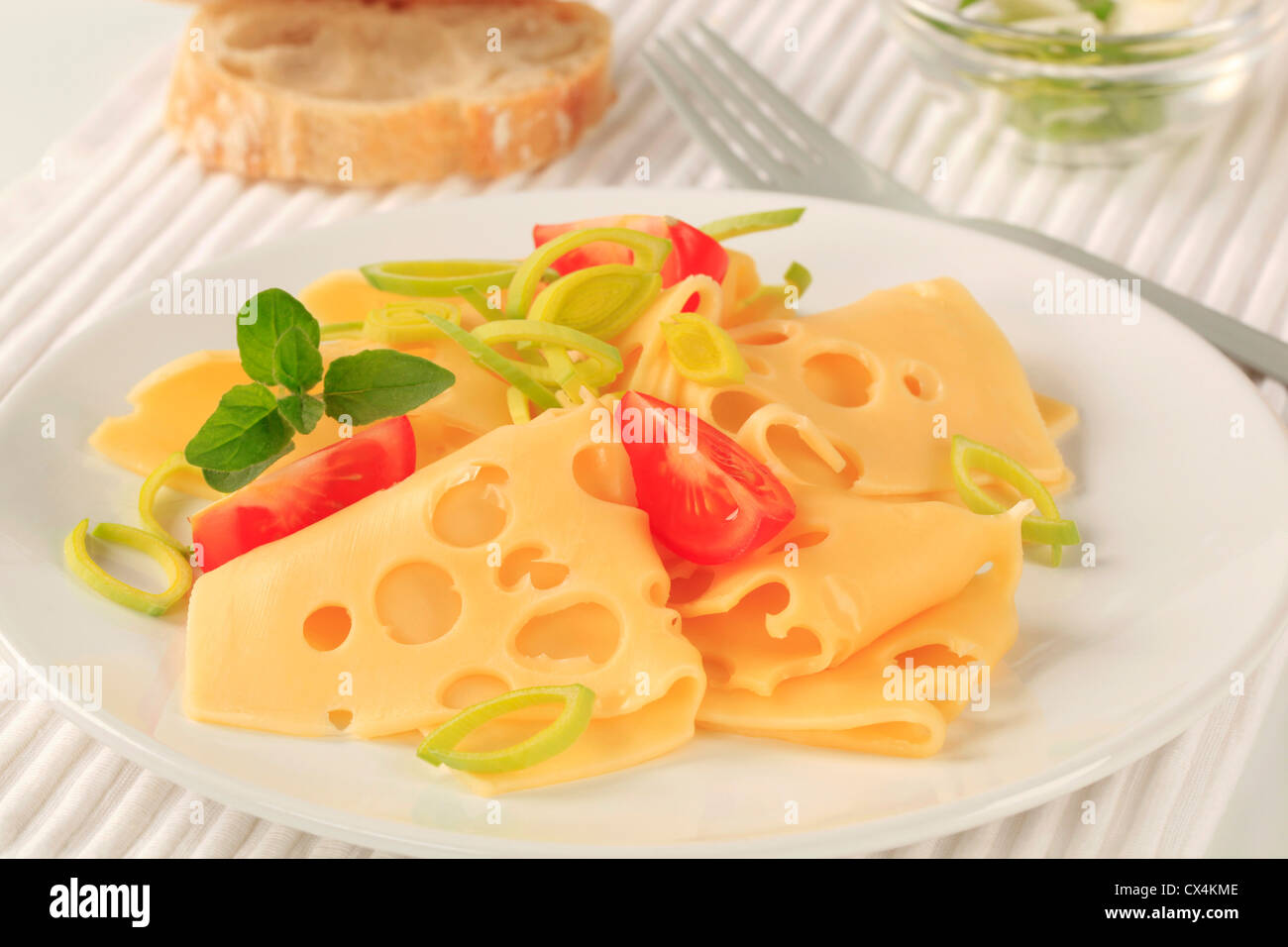 Slices of Swiss cheese sprinkled with spring onion Stock Photo - Alamy