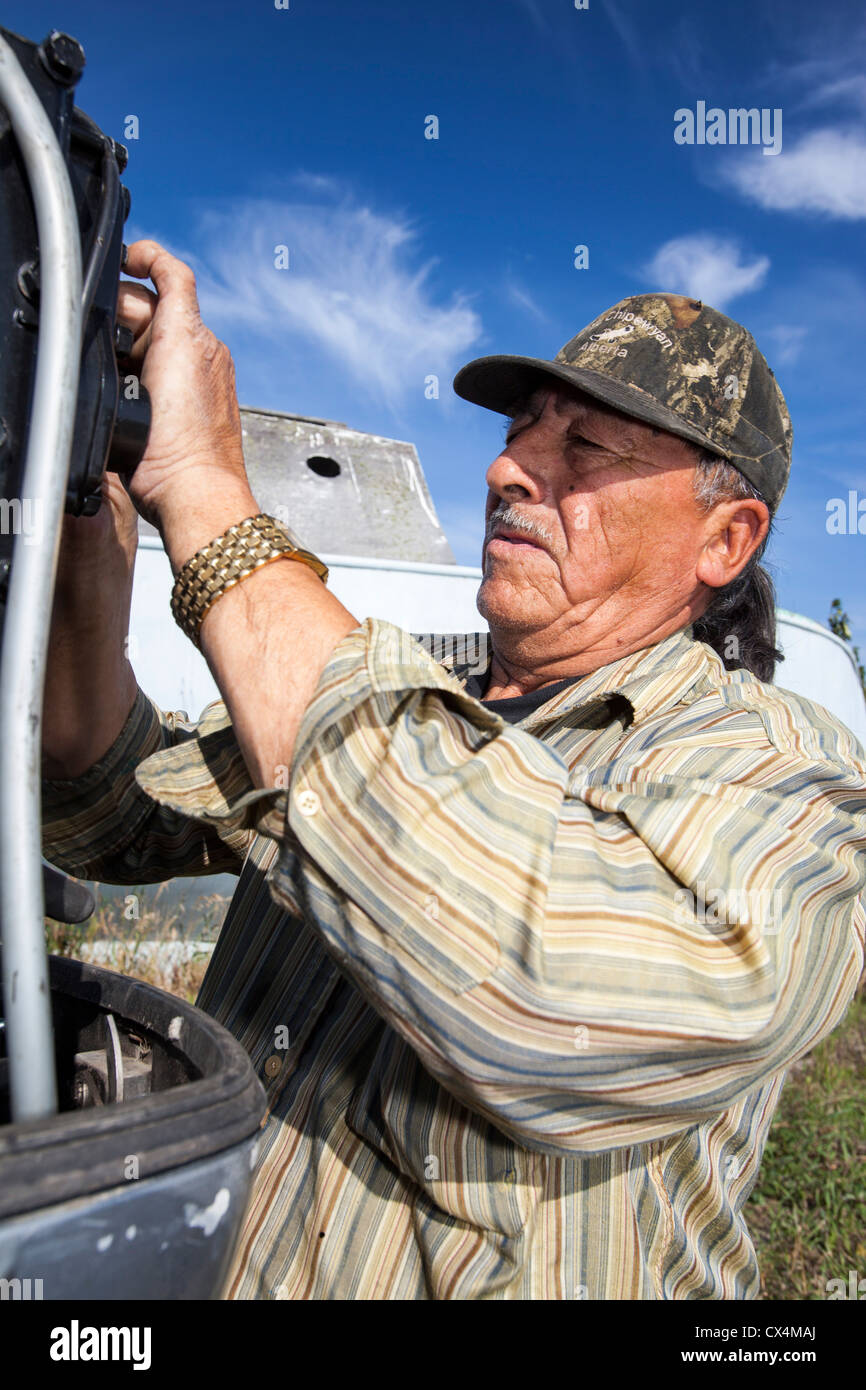 Louis Ladouceur fixing his outboard motor, a first nation resident of ...