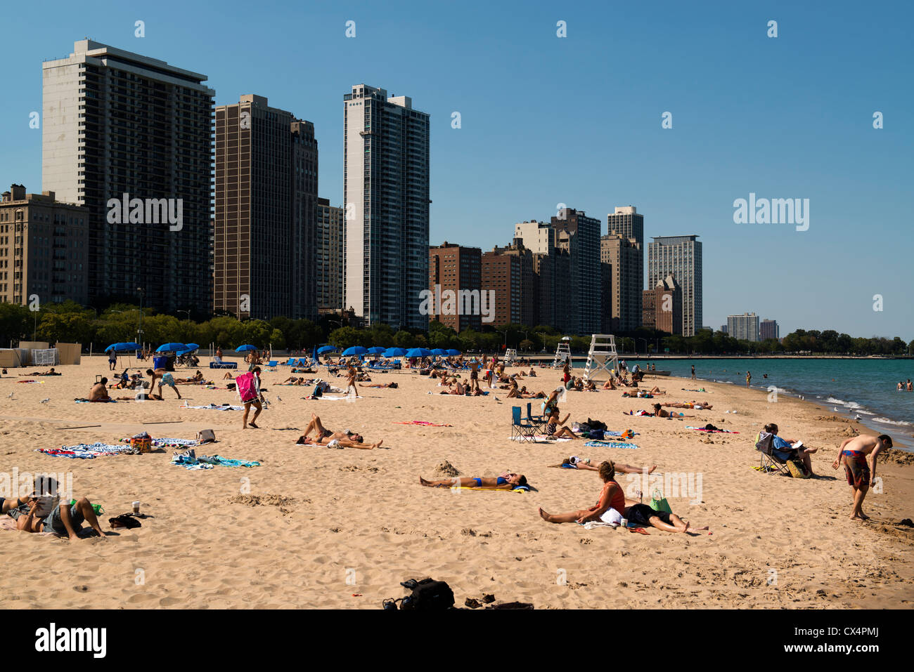 Bathers on Oak Street Beach on a sunny day with high rise buildings ...