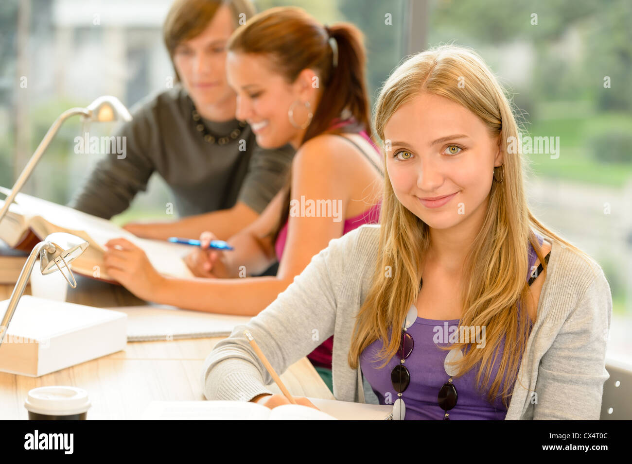 High-school student taking notes in study room smiling education campus ...