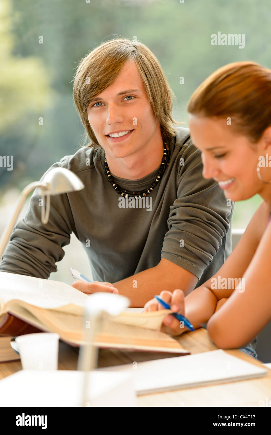 Teens reading book studying in high-school library campus young ...
