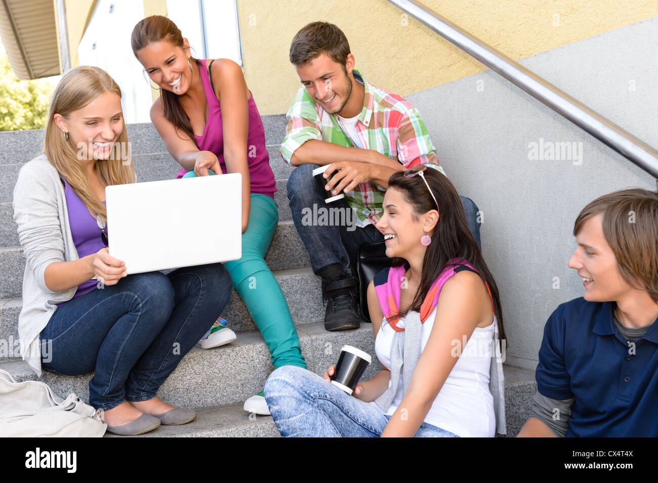 Students having fun with laptop school stairs teens college laughing ...