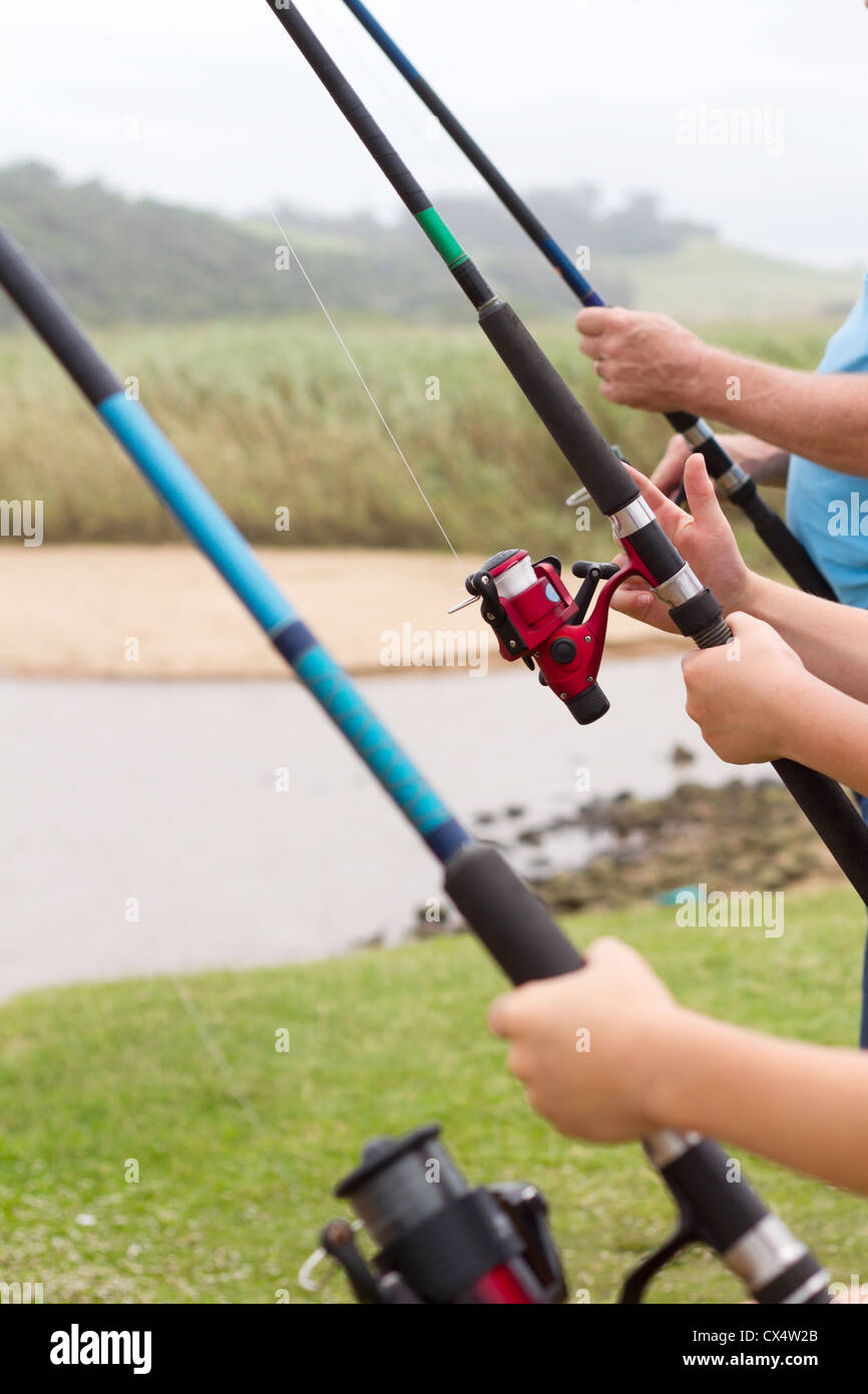 closeup of three people holding fishing rods Stock Photo - Alamy