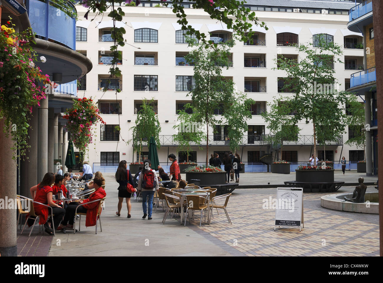 People at tables in open air terrace cafe in Tower Bridge Piazza ...