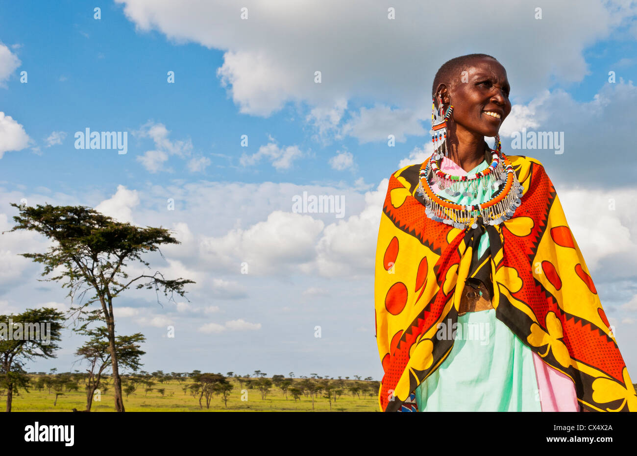Kenya Masai Mara reserve with Masai woman in colorful dress with blue ...
