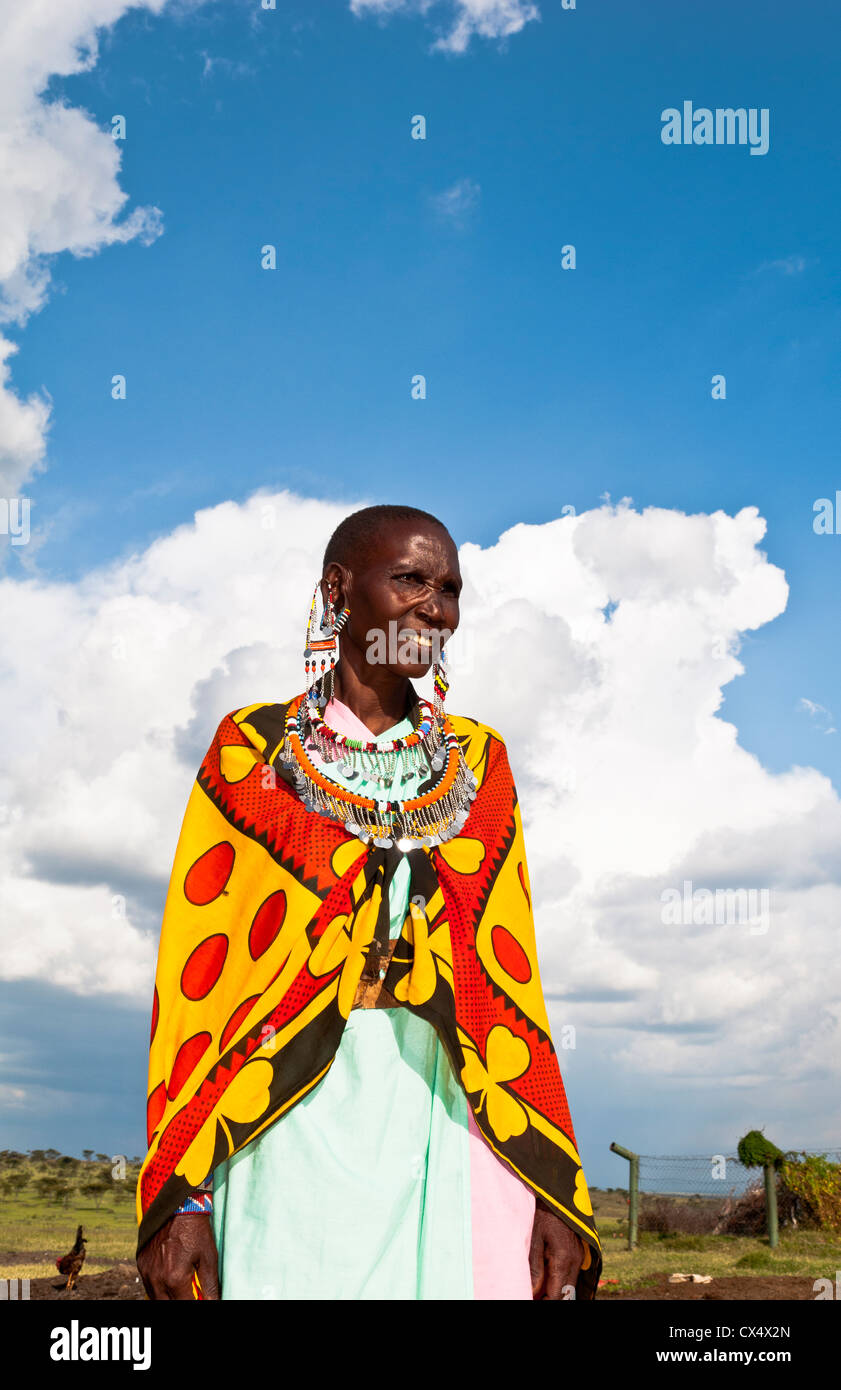Kenya Masai Mara reserve with Masai woman in colorful dress with blue ...