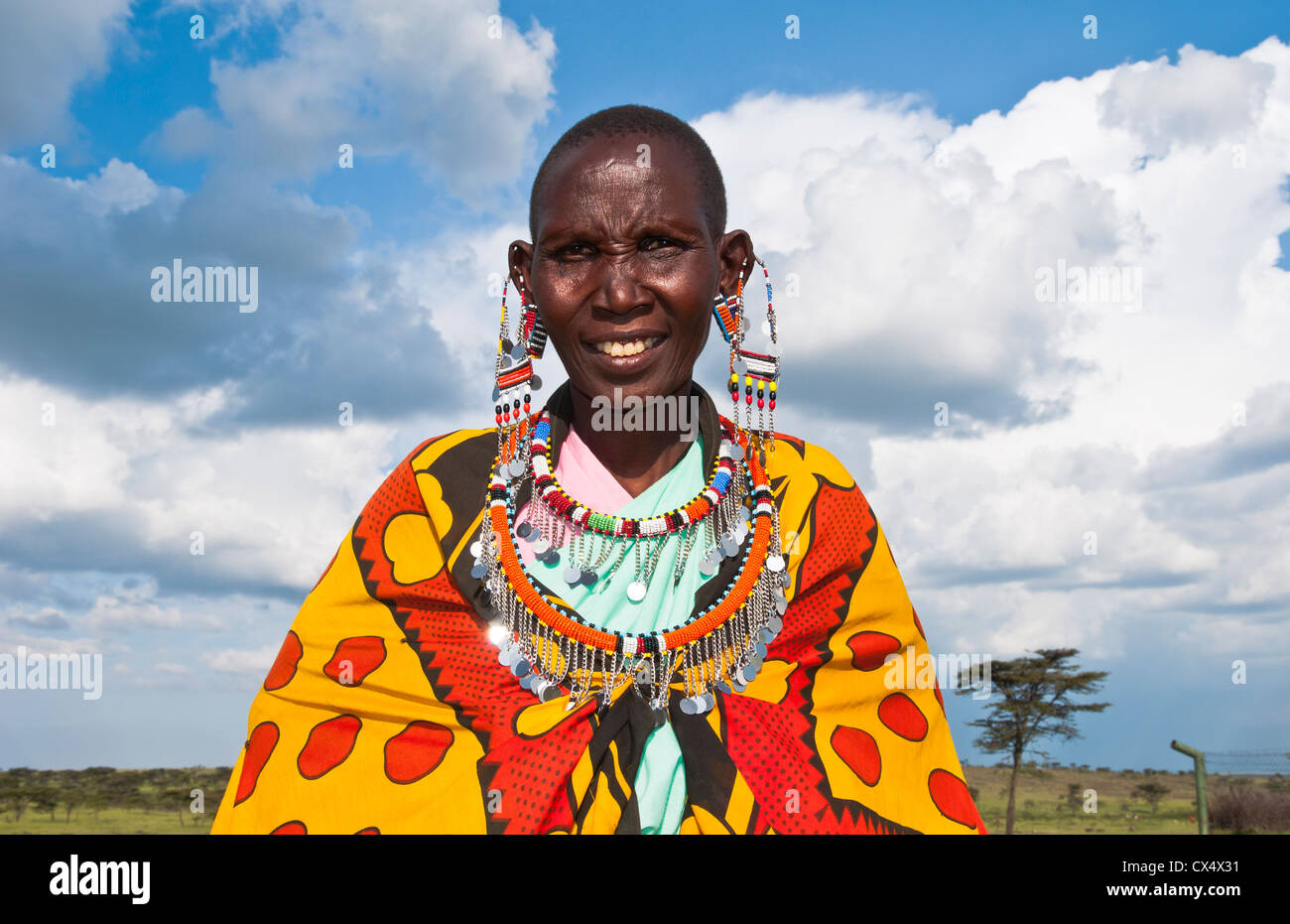 Kenya Masai Mara reserve with Masai woman in colorful dress with blue ...