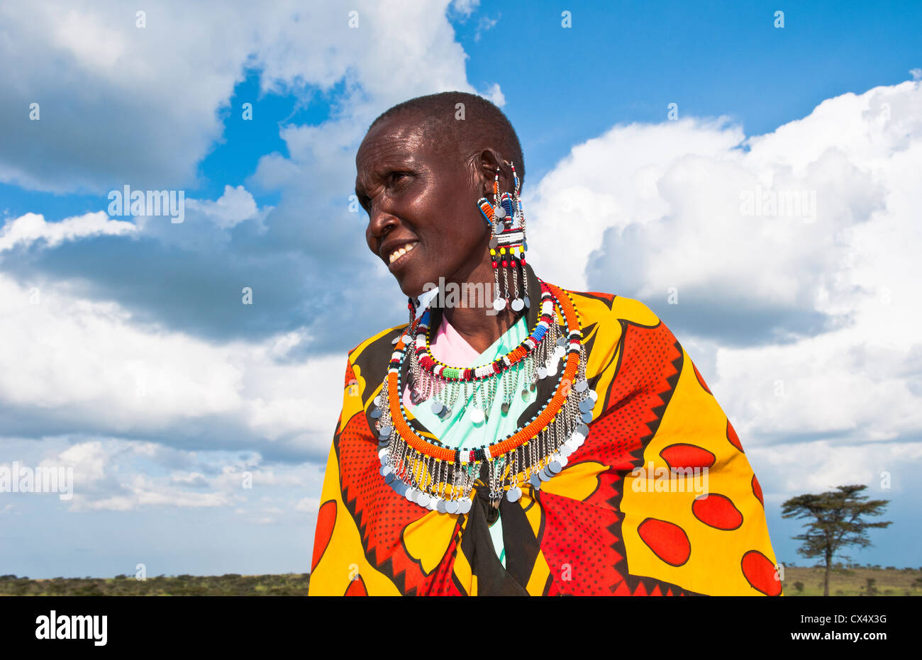 Kenya Masai Mara reserve with Masai woman in colorful dress with blue ...
