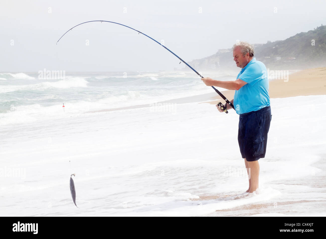 senior man catching a fish with fishing rod on beach Stock Photo - Alamy