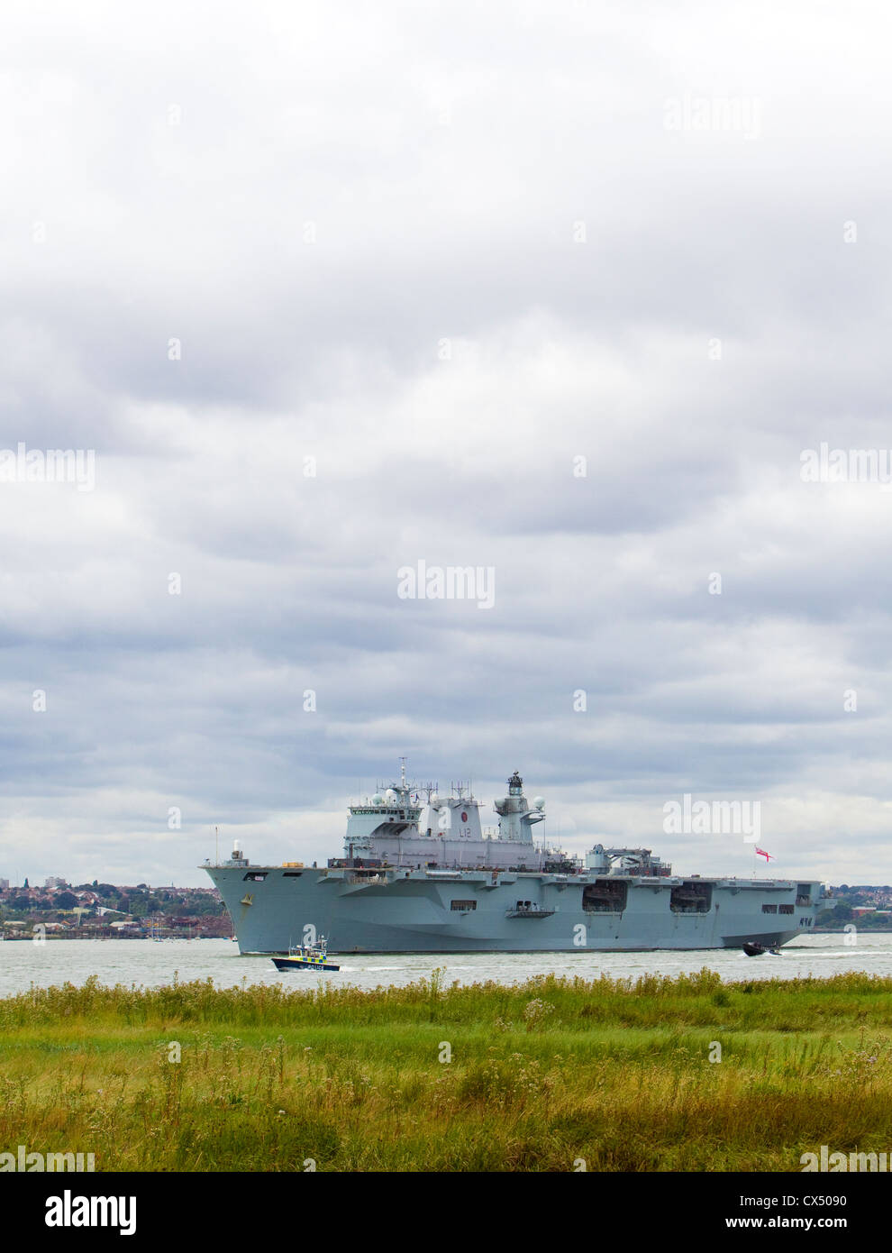 HMS Ocean, amphibious assault ship, making way down River Thames after ...