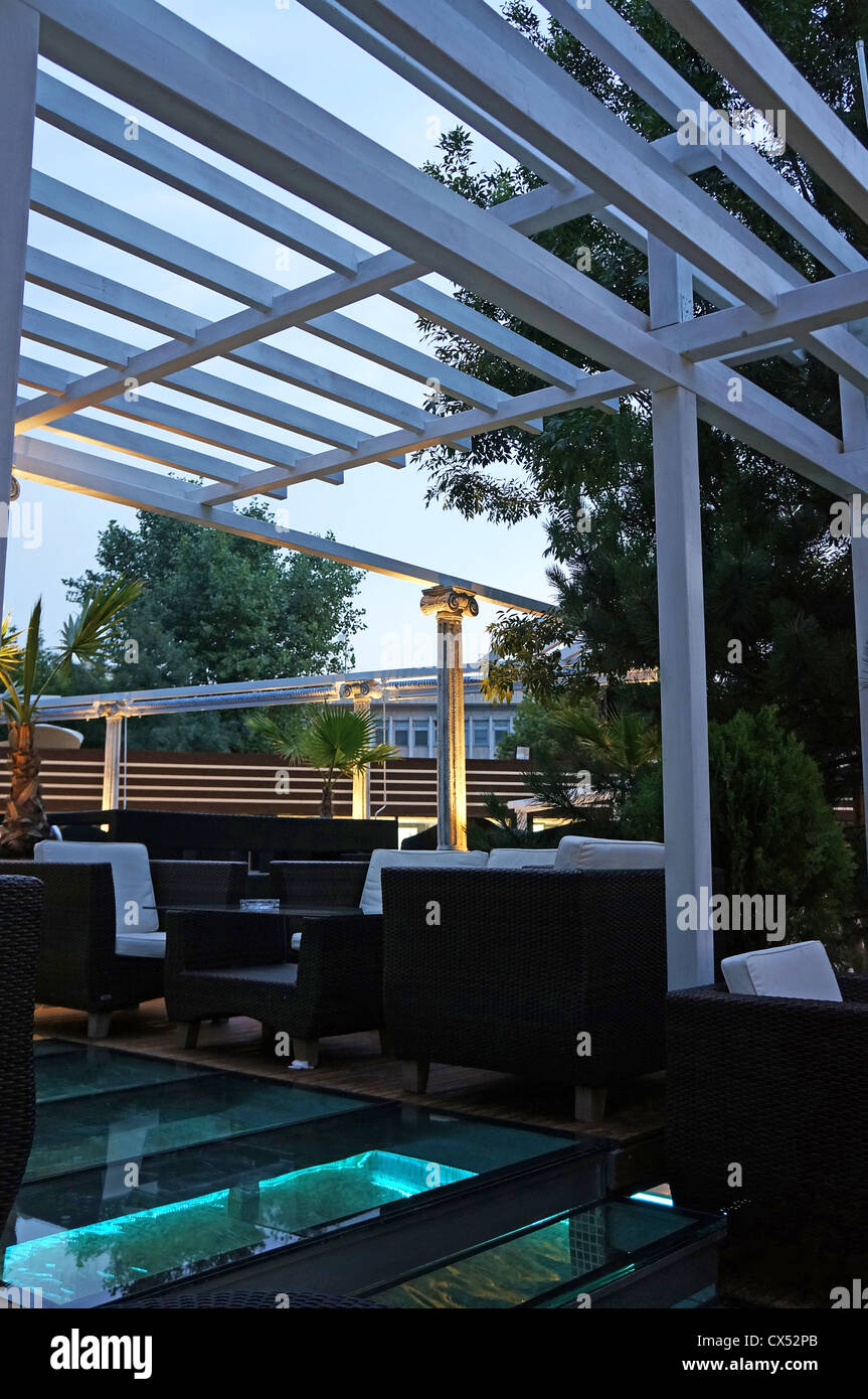 Outdoors view of a neoclassical garden with armchairs and external ...