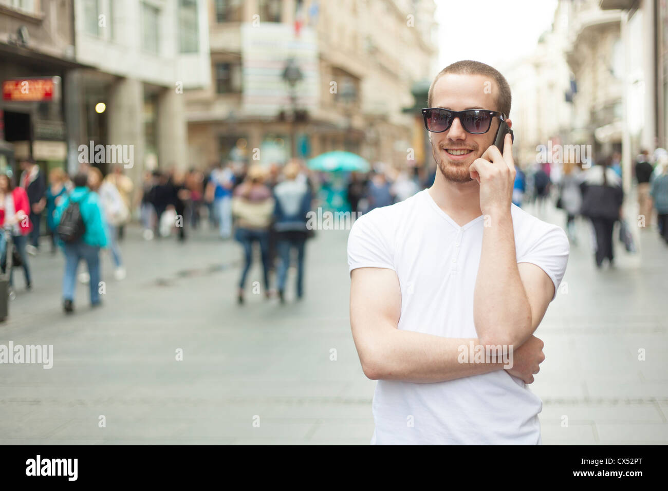 Men with mobile phone walking, blured city is background Stock Photo ...