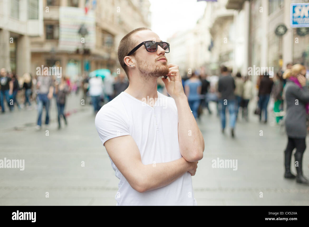 Young Man with mobile phone walking, background is blured city Stock ...
