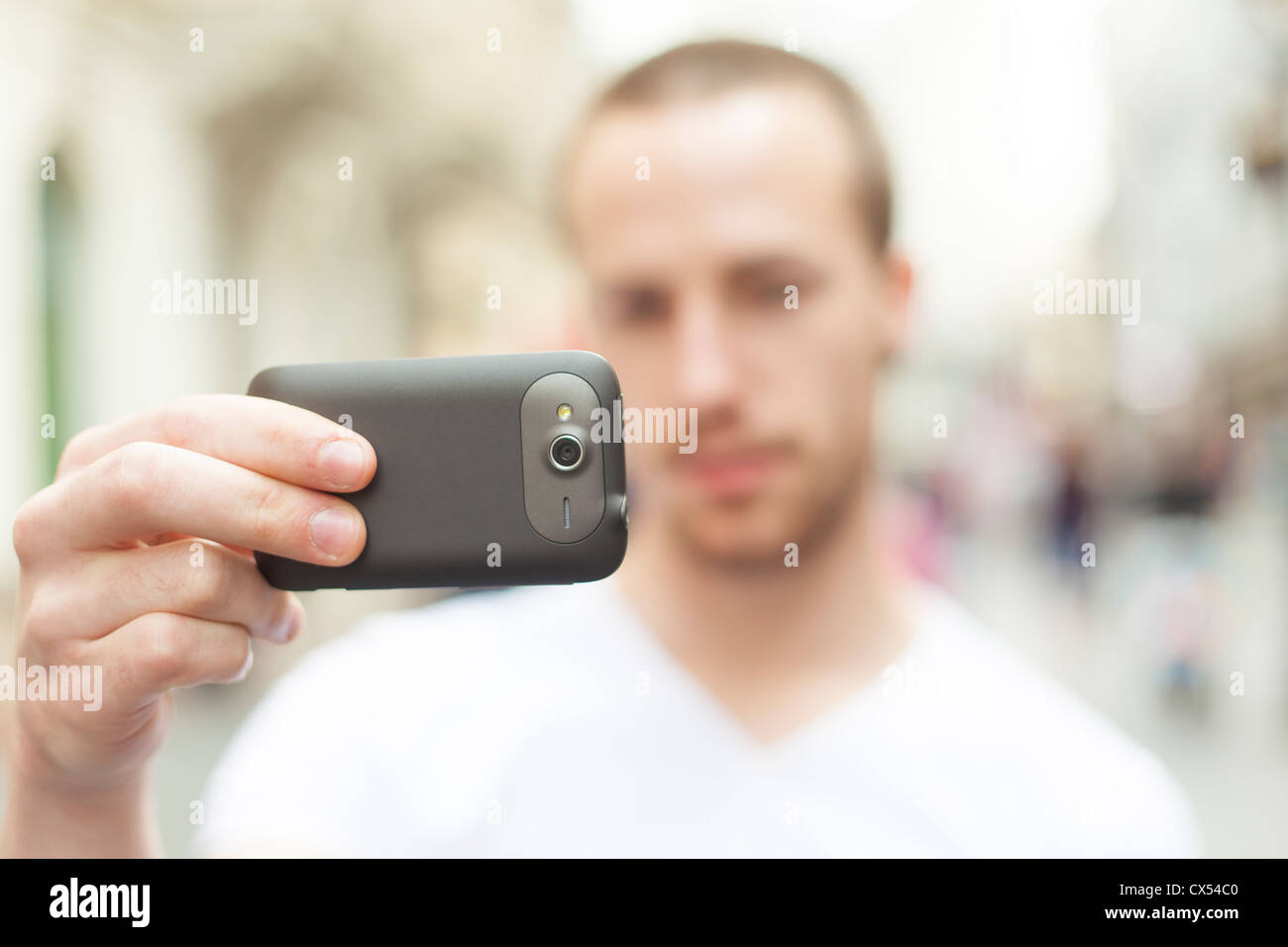 Urban photographer with mobile phone make photo on street Stock Photo ...