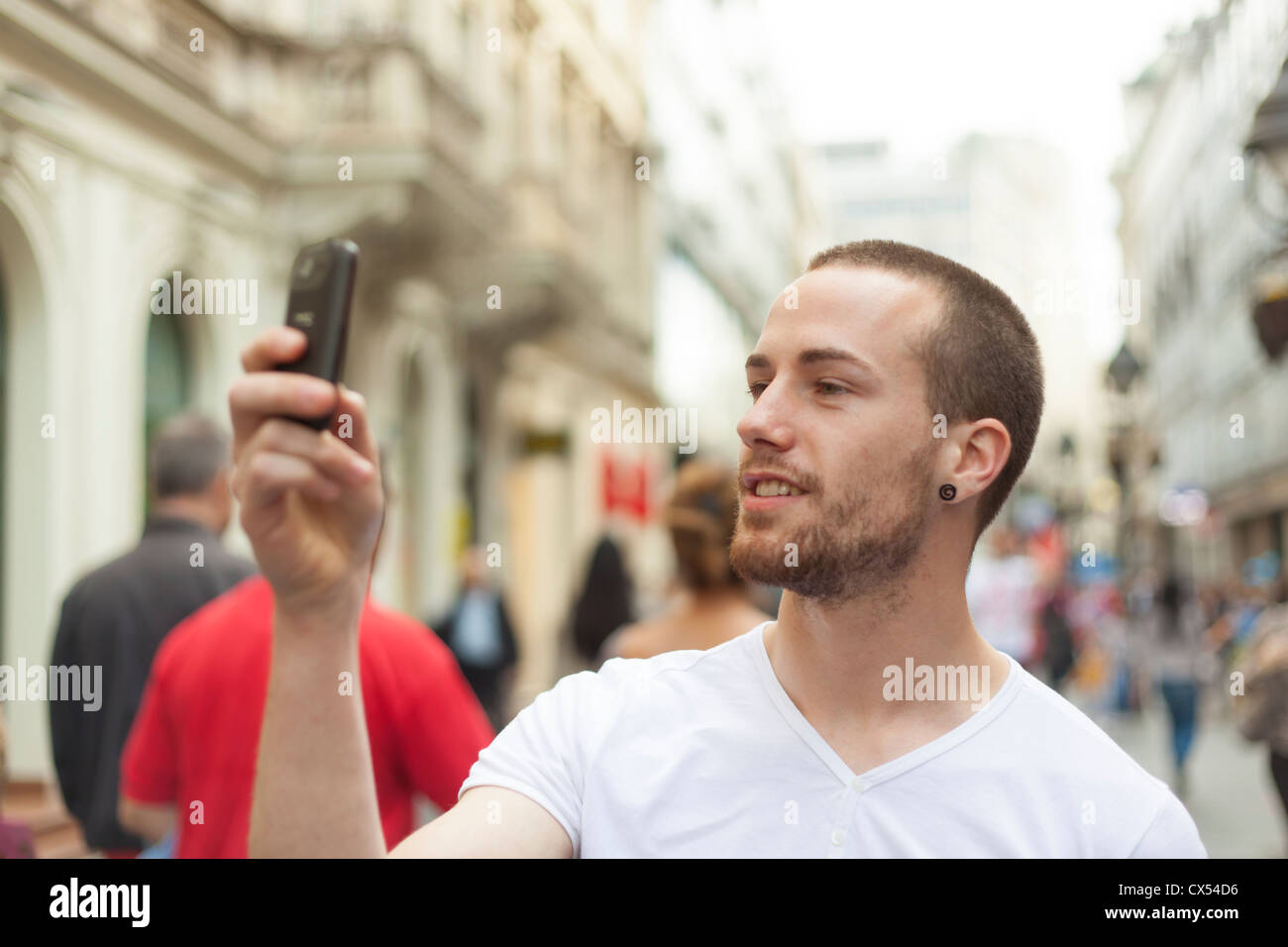 Urban photographer with mobile phone make photo on street Stock Photo ...