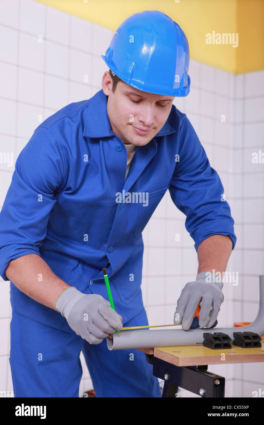 young technician cutting a pipe Stock Photo - Alamy