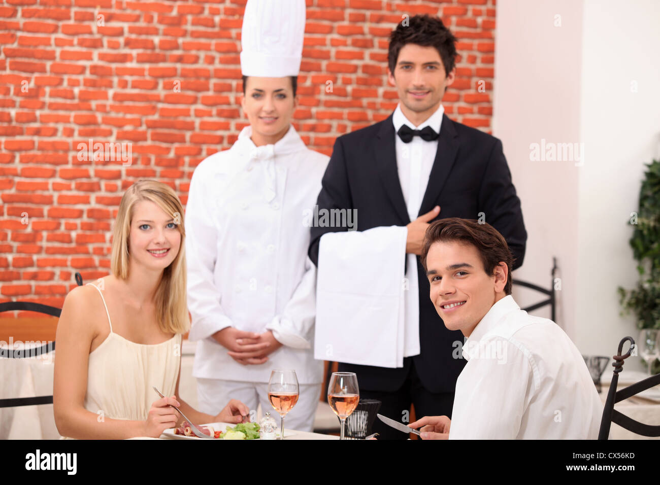 Restaurant staff stood with customers Stock Photo - Alamy