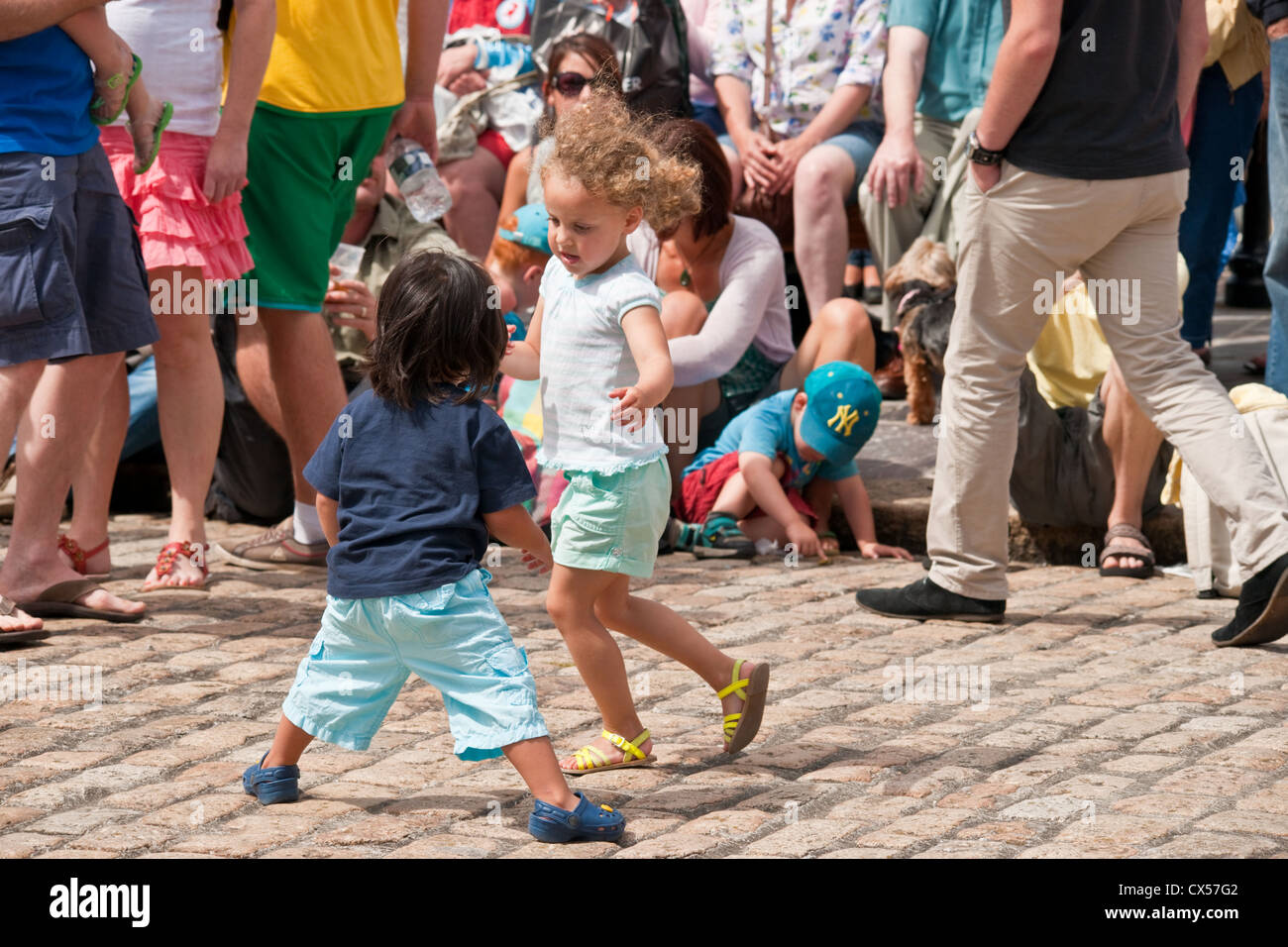 A crowd gathered to watch people dance in the street at a jazz festival ...