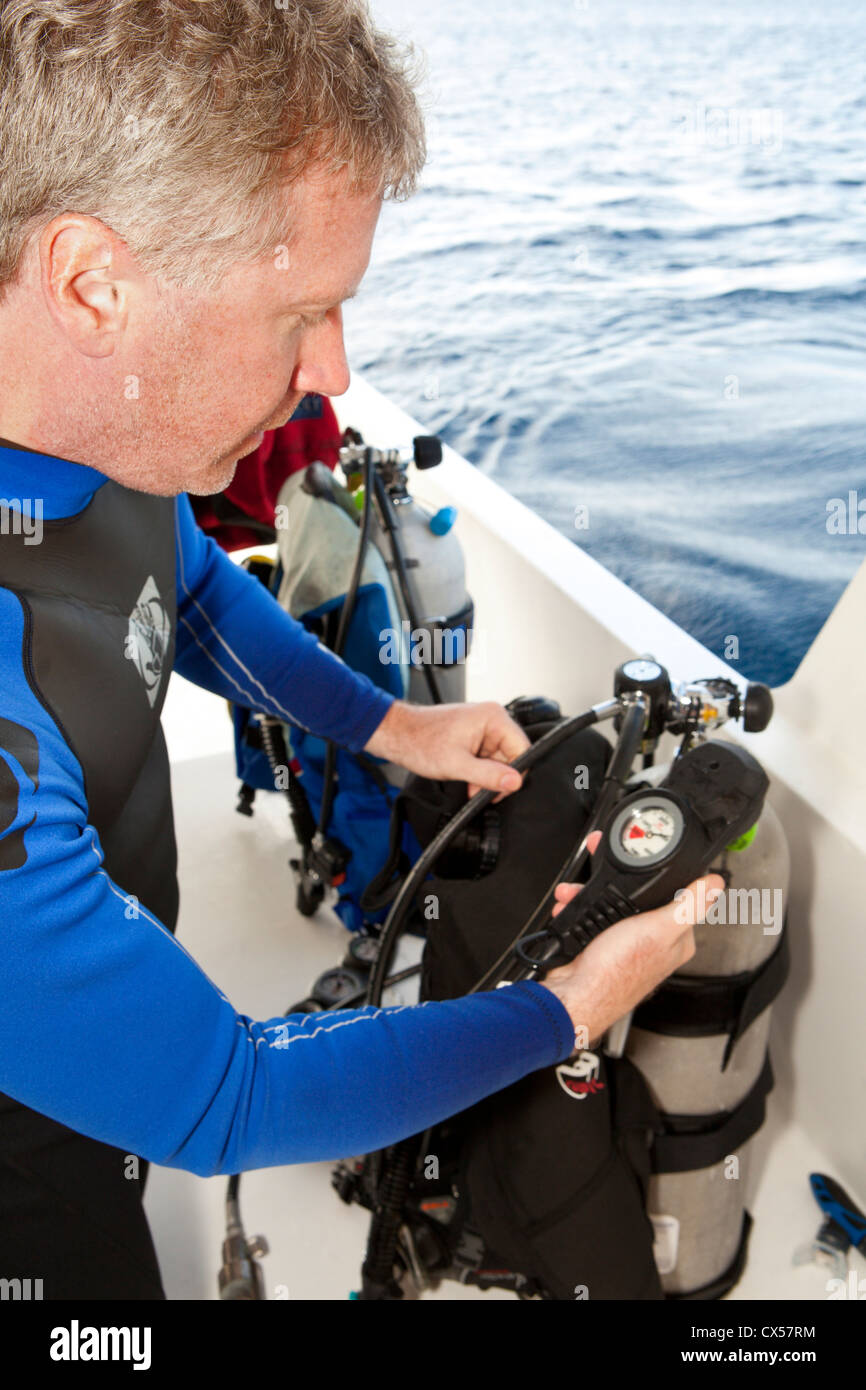 Diver checking tank fill. Central America, Belize. (MR Stock Photo - Alamy