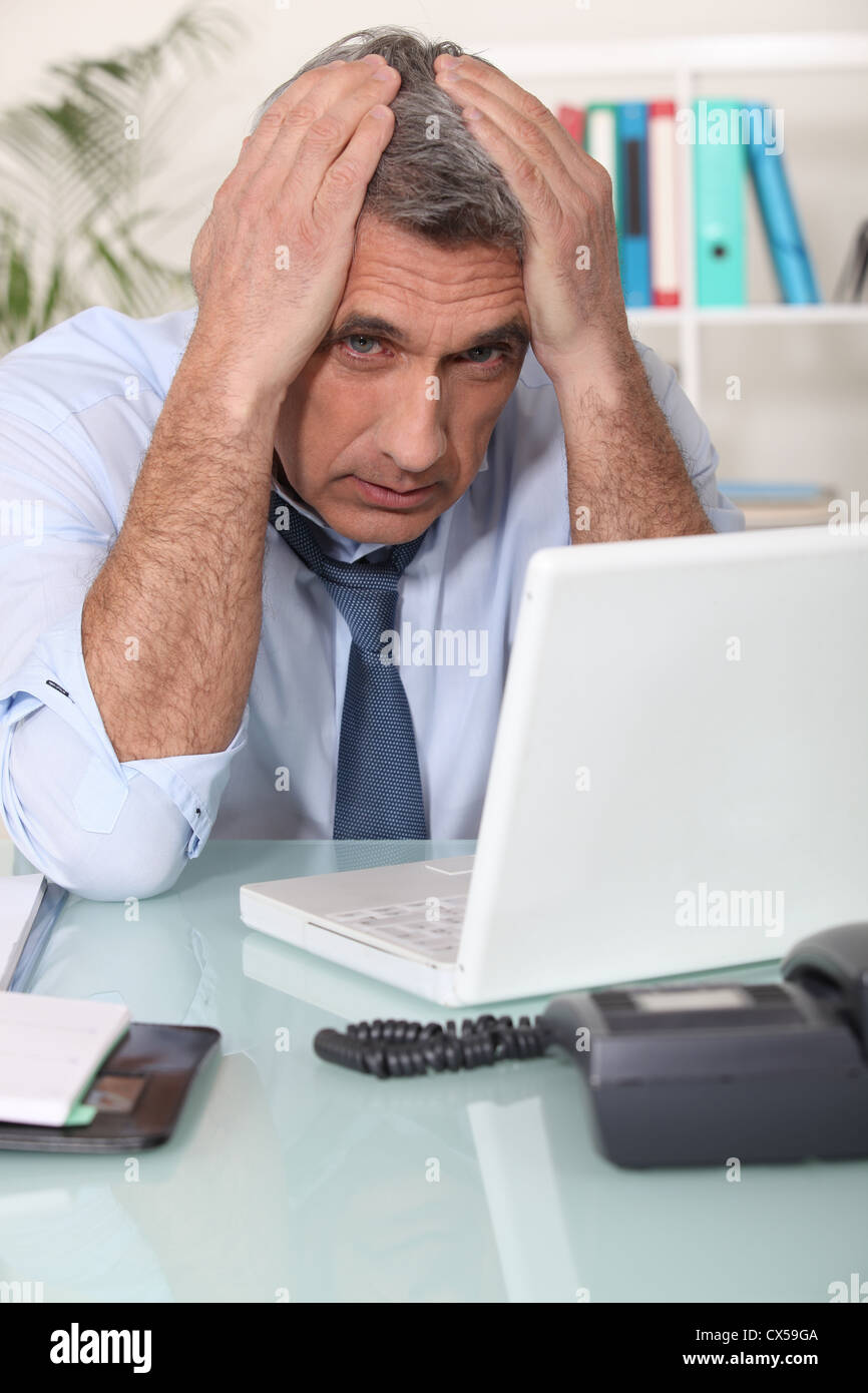 Stressed man using laptop Stock Photo - Alamy
