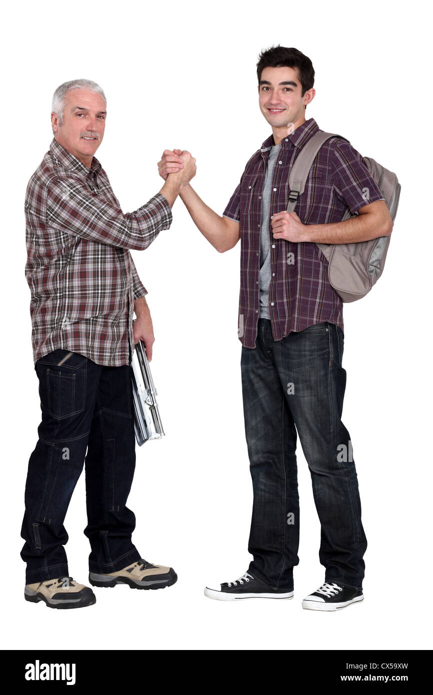 Experienced tradesman making a pact with his new apprentice Stock Photo ...