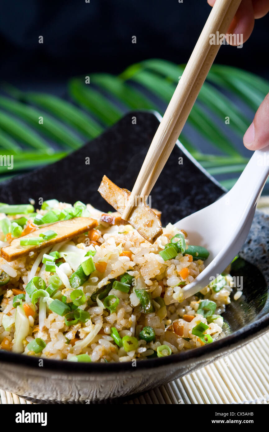 eating Chinese stir fry rice with chopsticks and spoon Stock Photo - Alamy