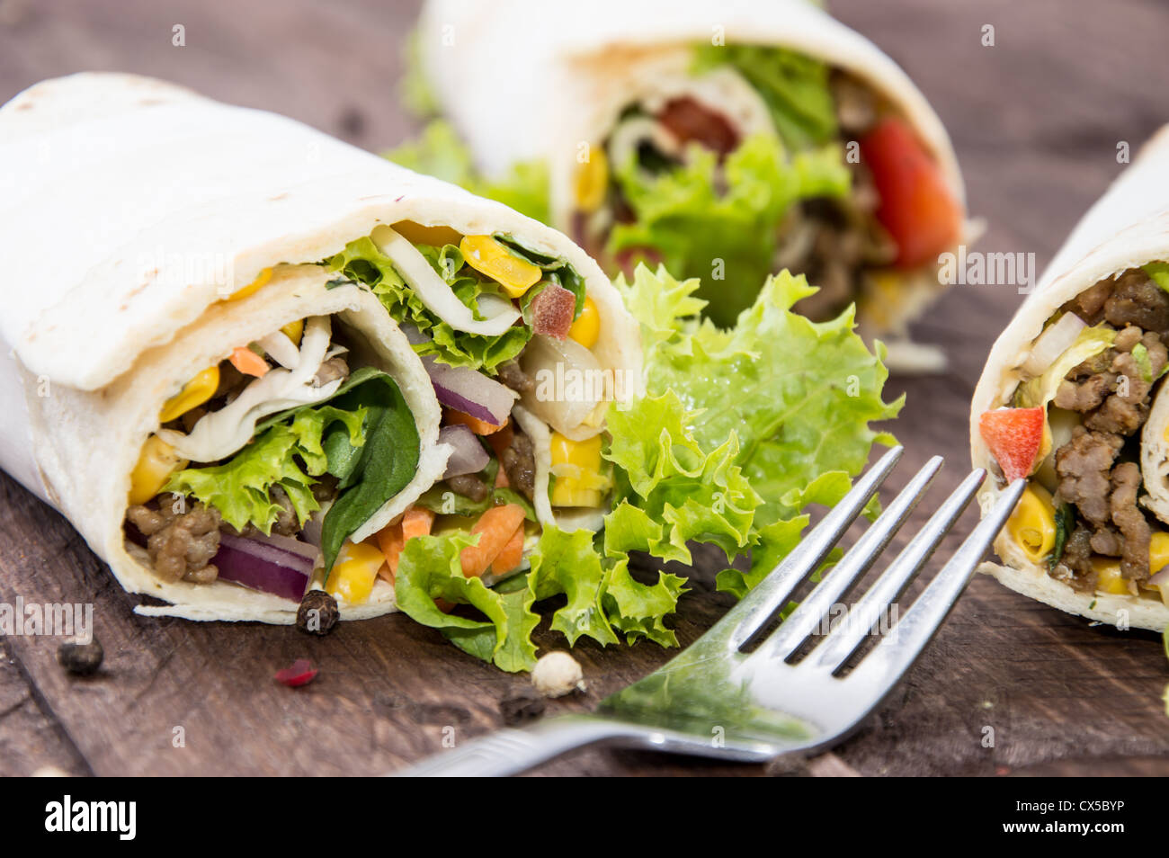 Some fresh made Wraps on wooden background Stock Photo - Alamy