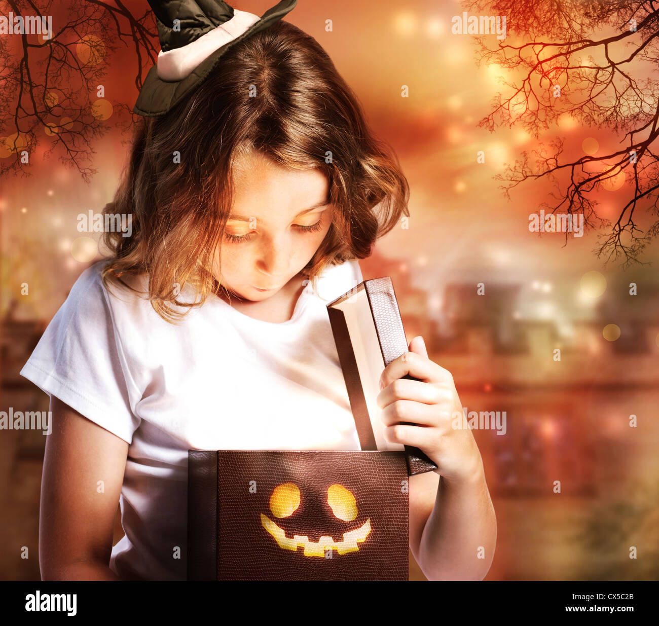 Halloween Cute Little Witch Opening a Box Stock Photo - Alamy