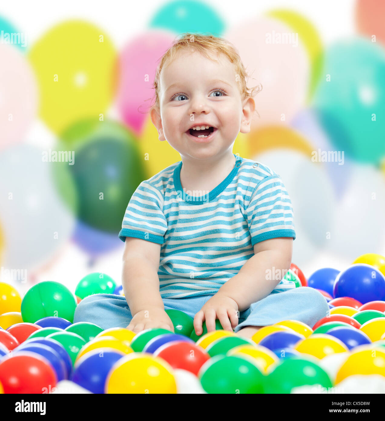 Cute boy playing colorful balls Stock Photo - Alamy