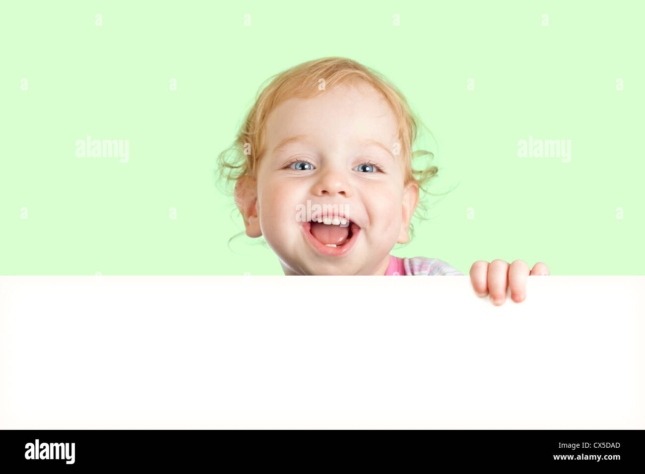 Happy child face behind blank advertising banner. Banner and green ...
