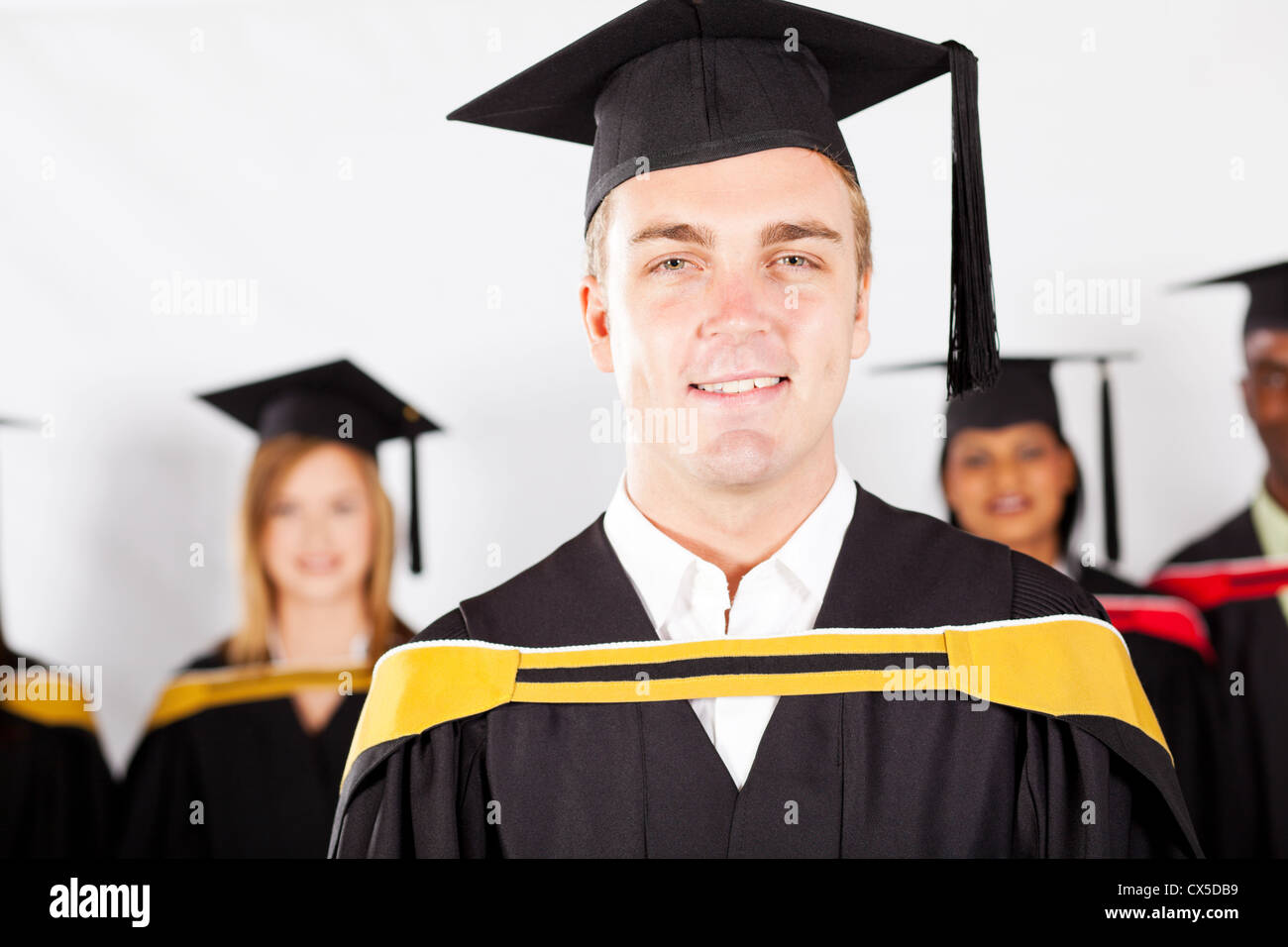 happy male college graduate with classmates at graduation Stock Photo ...