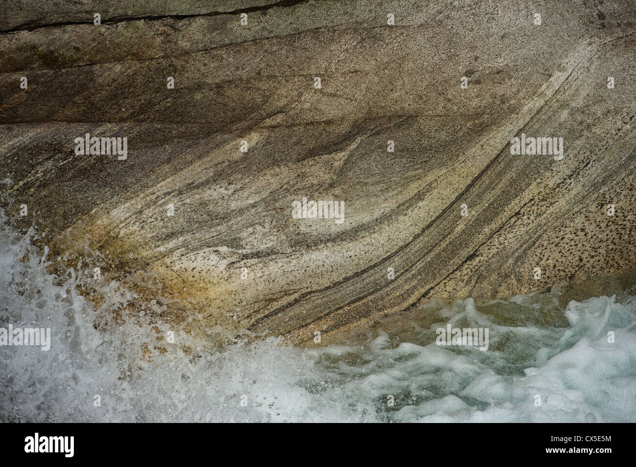 White rock with gray lines with green water flowing around it in the ...