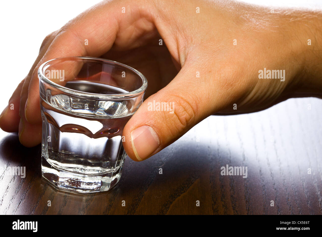 glass of clear alcohol in hand Stock Photo - Alamy