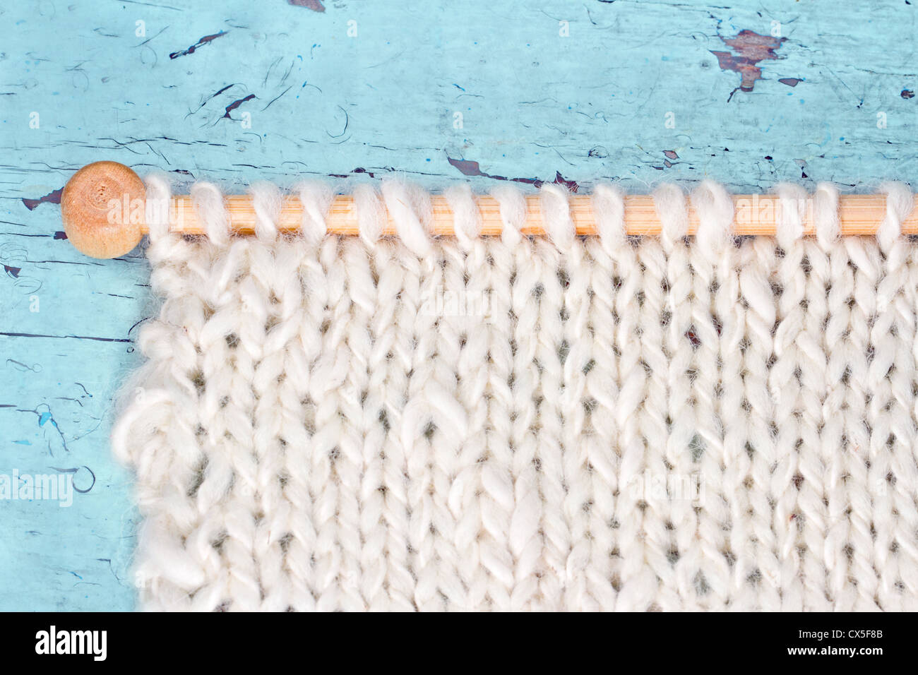 White knitting on rustic wooden blue background Stock Photo - Alamy